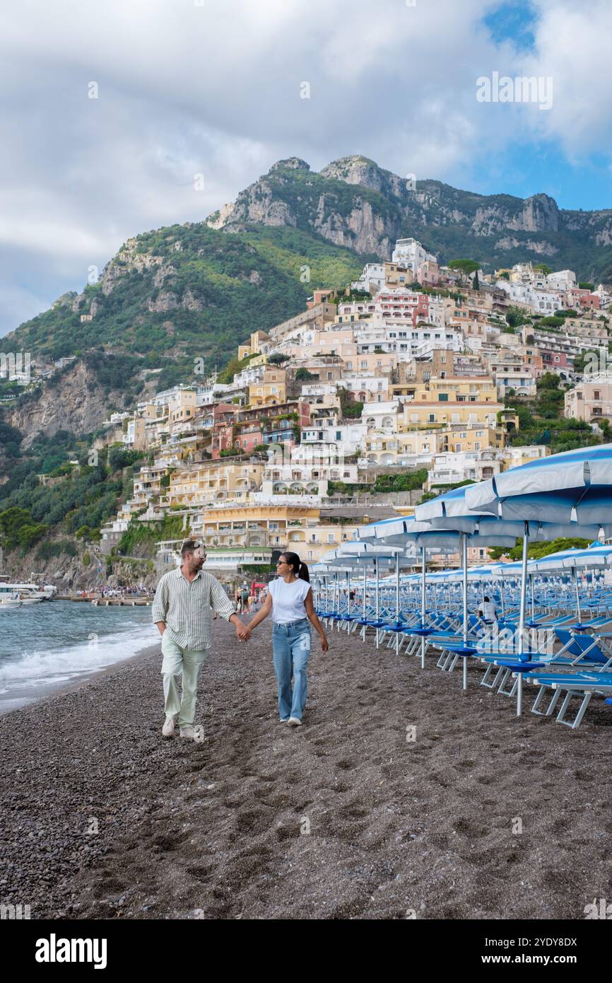 A couple enjoys a romantic walk along the sandy shore, surrounded by ...