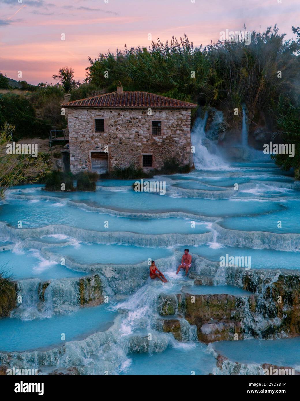 Thermal waters of Saturnia, Tuscany, at sunrise, casting a warm glow ...