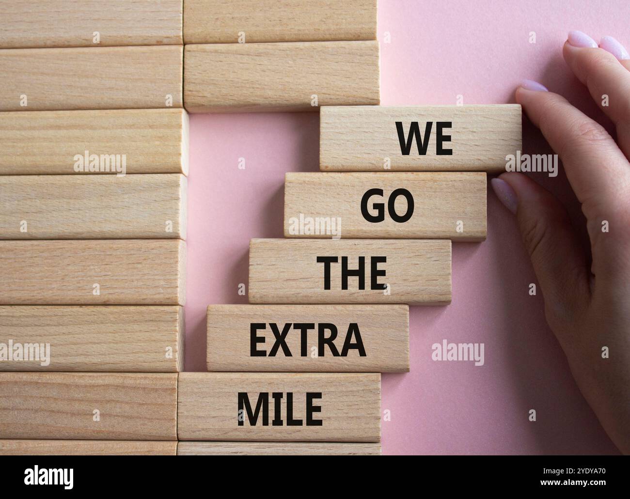 We go the extra mile symbol. Wooden blocks with words We go the extra ...