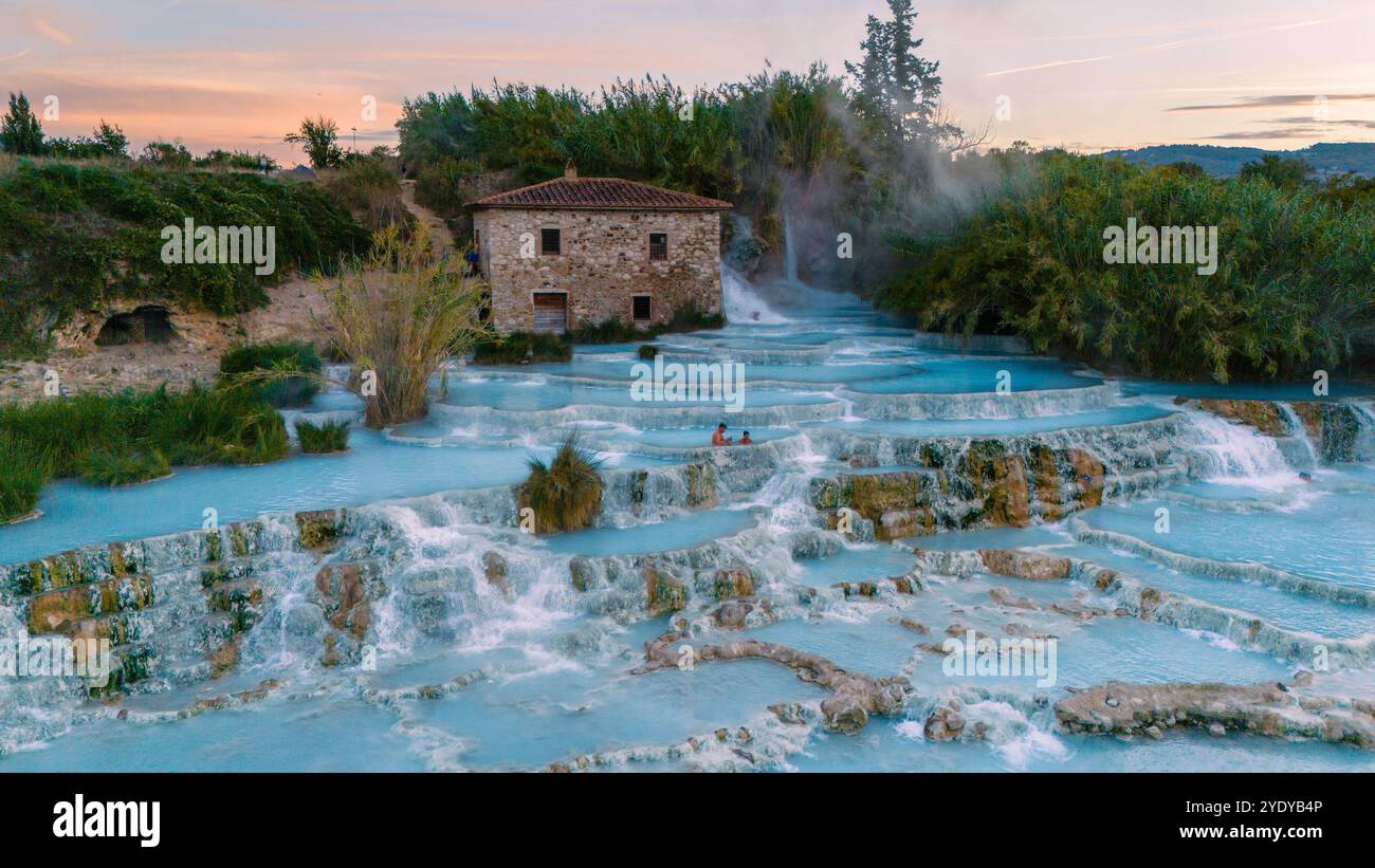 Warm steam rises as visitors relax in the natural thermal waters of ...