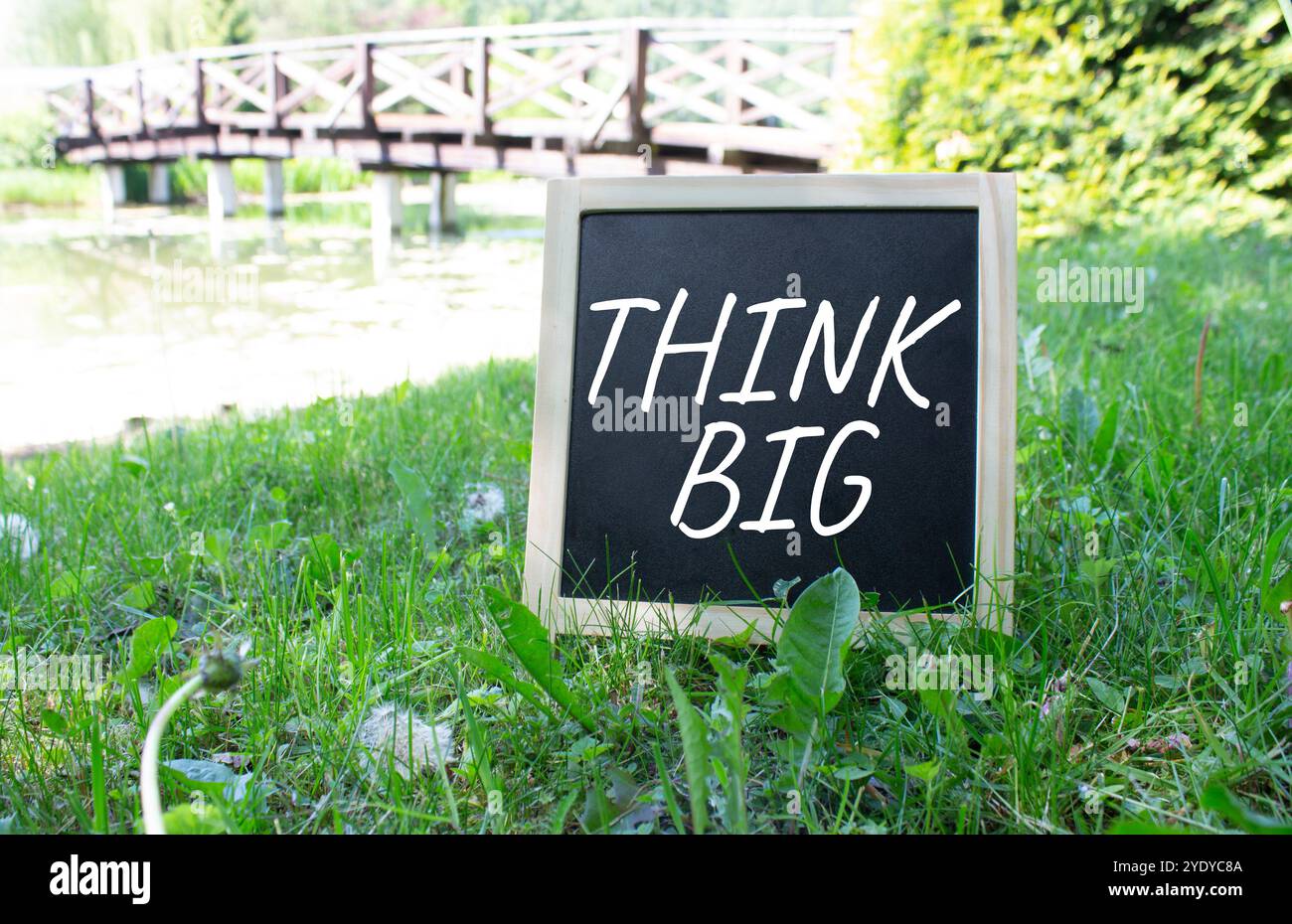 Think big symbol. Concept words Think Big on black chalk background ...