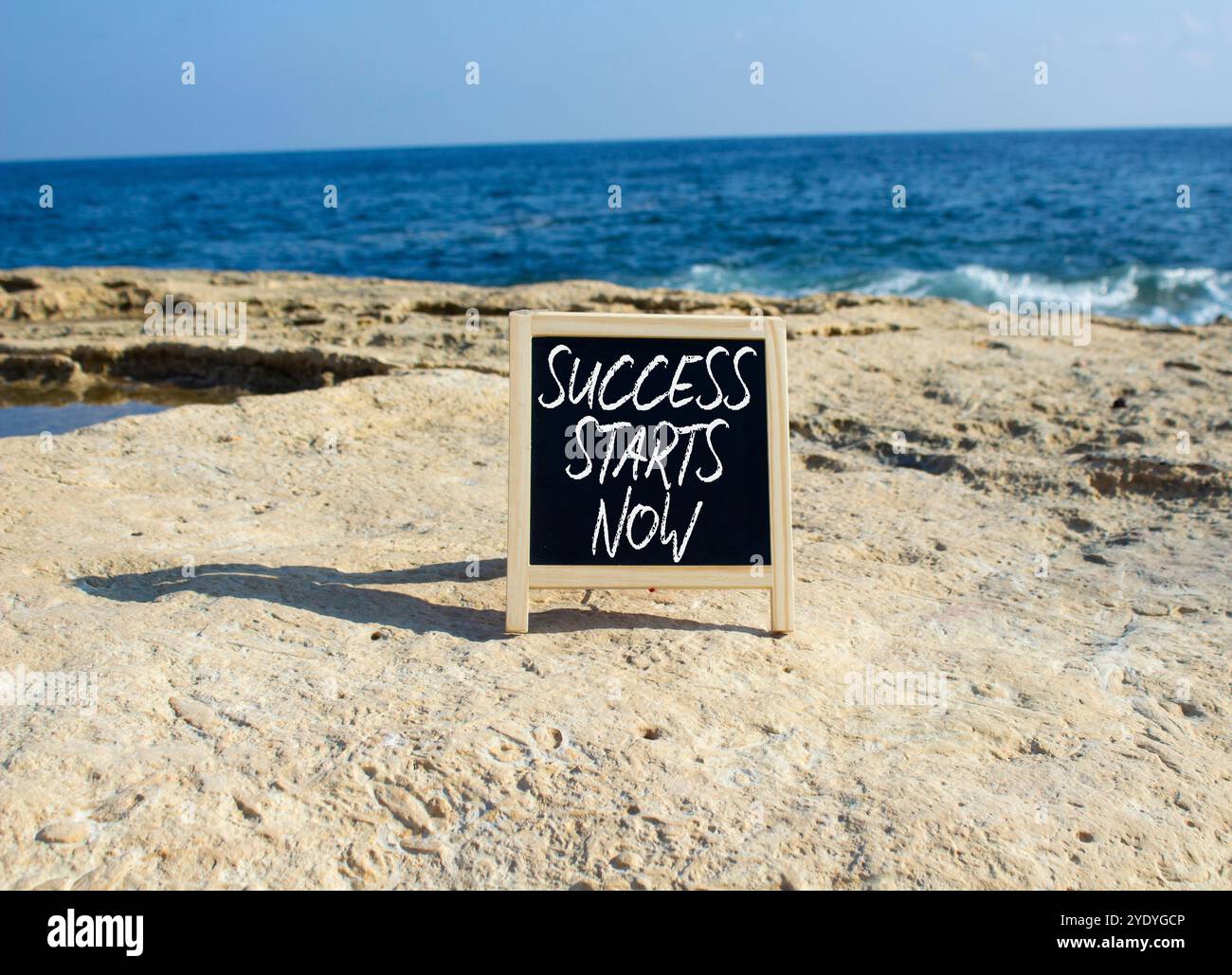 Success Starts Now symbol. Concept words Success Starts Now on black chalk blackboard. Beautiful ...