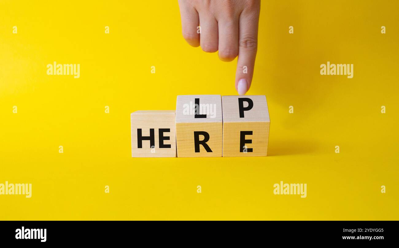 Help is here symbol. Businessman hand points at cube with words Here to ...