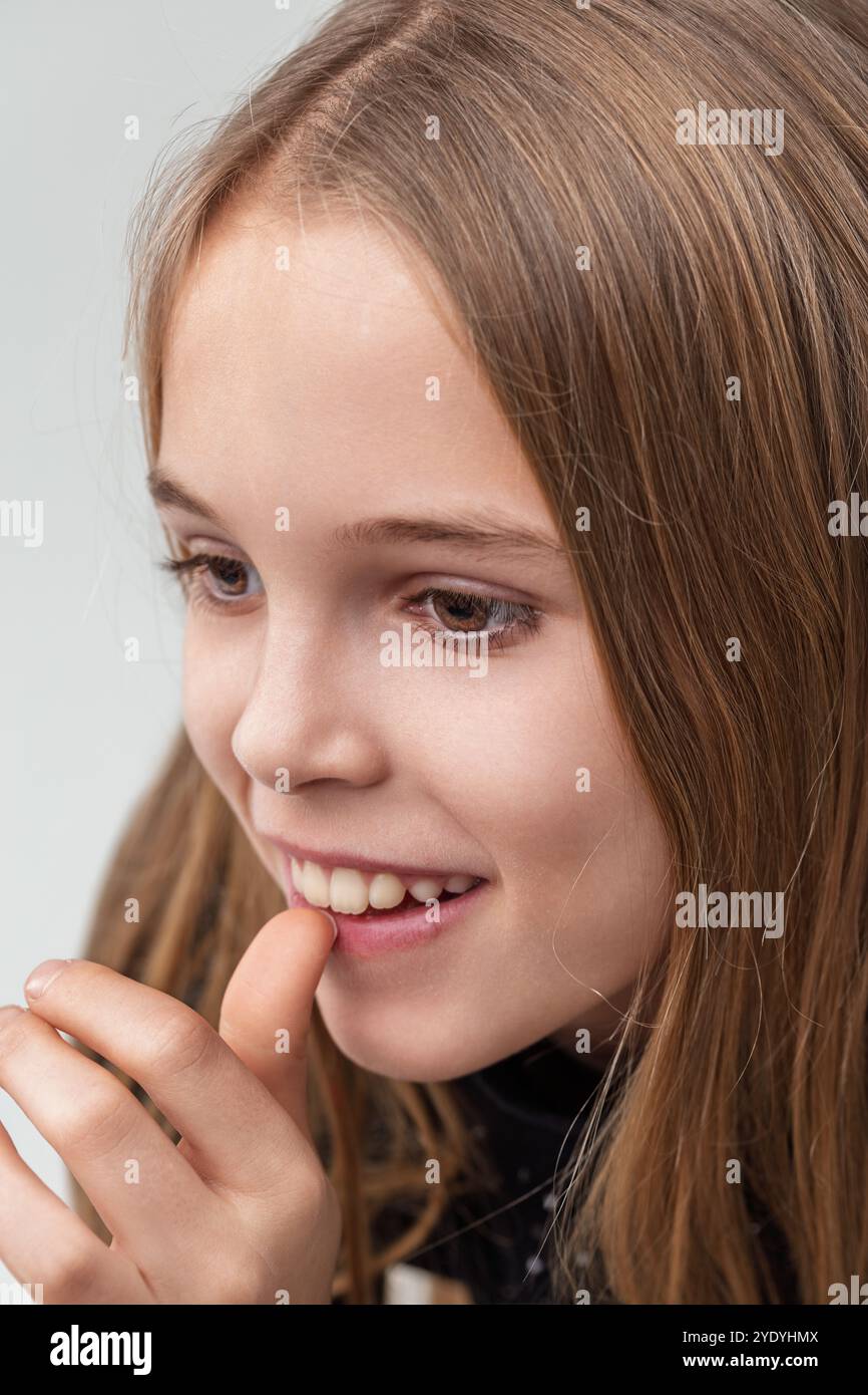 Close up portrait of a thoughtful young girl gently biting her ...