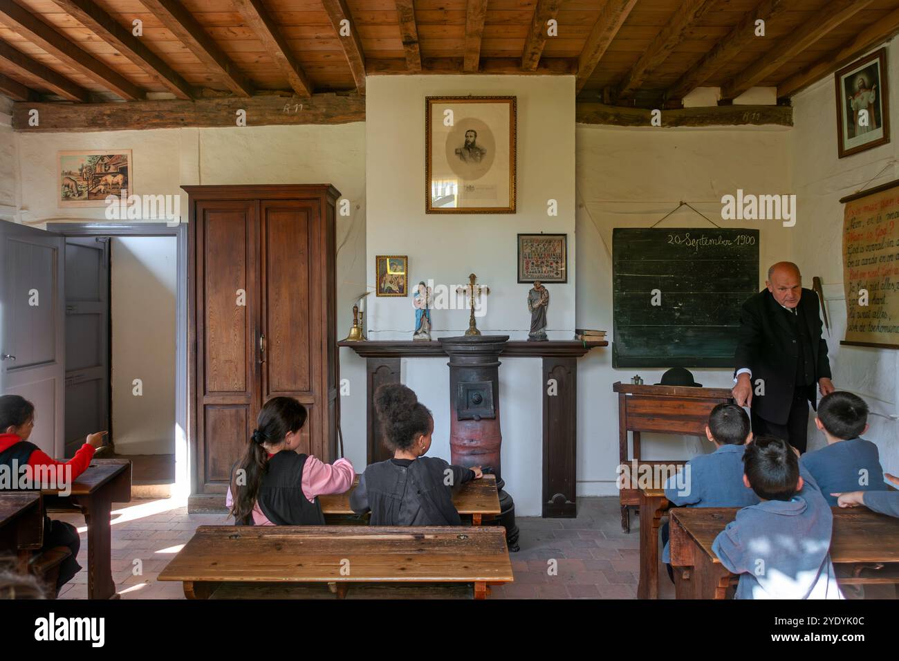 Actor playing old school teacher teaching school children in 19th ...