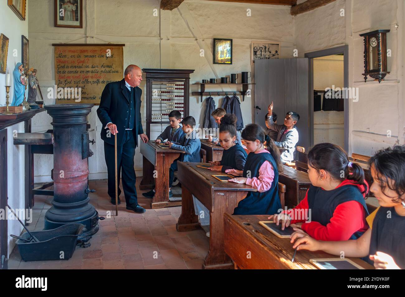 Actor playing old school teacher teaching school children in 19th ...