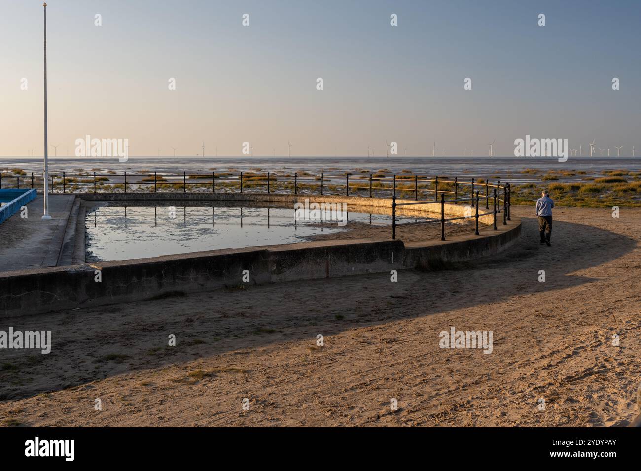 A man walks on Hoylake Beach, beside the old Hoylake Pool, on England's ...