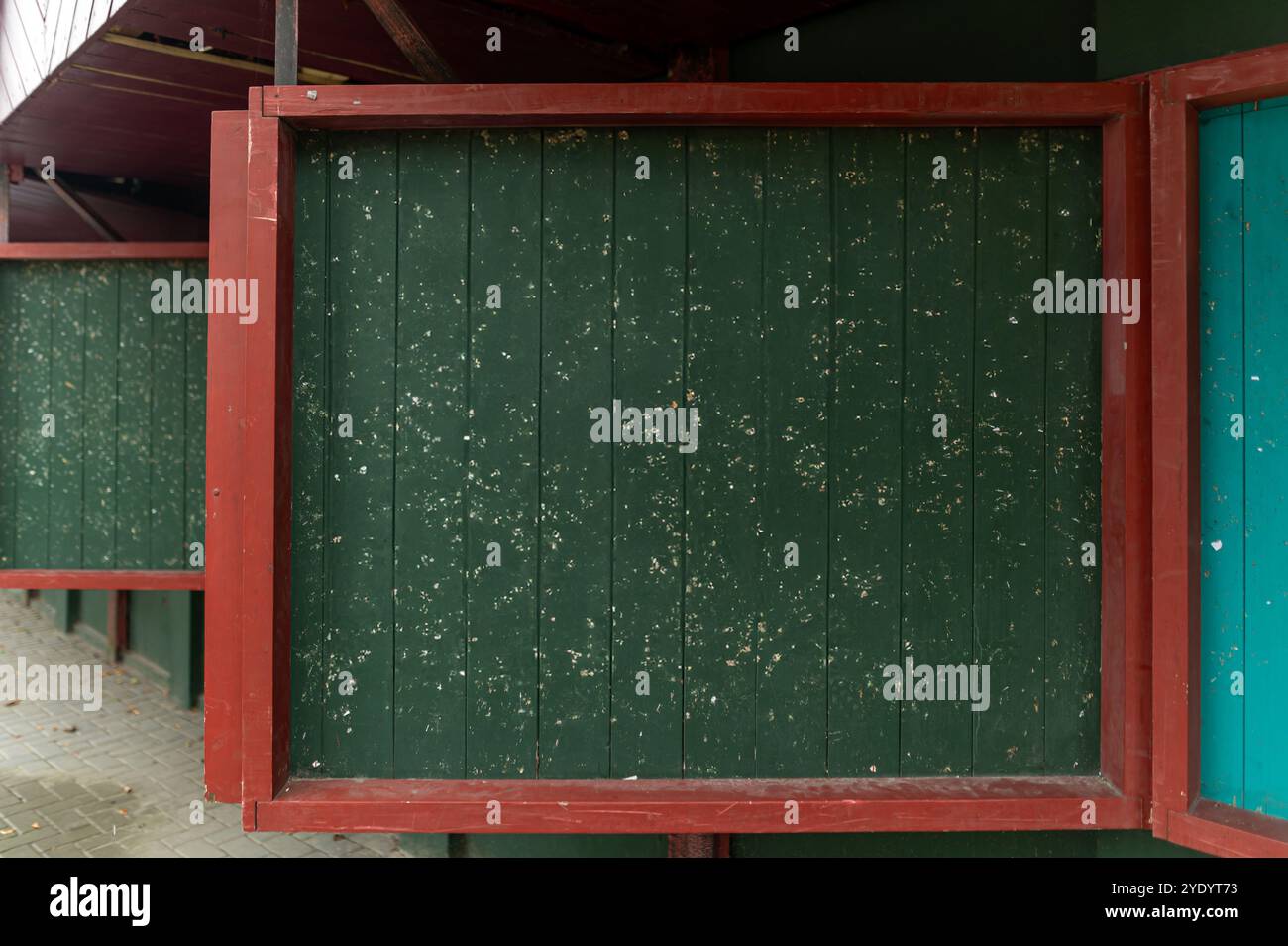 Green wooden boards with red frames at a market stall in early morning ...
