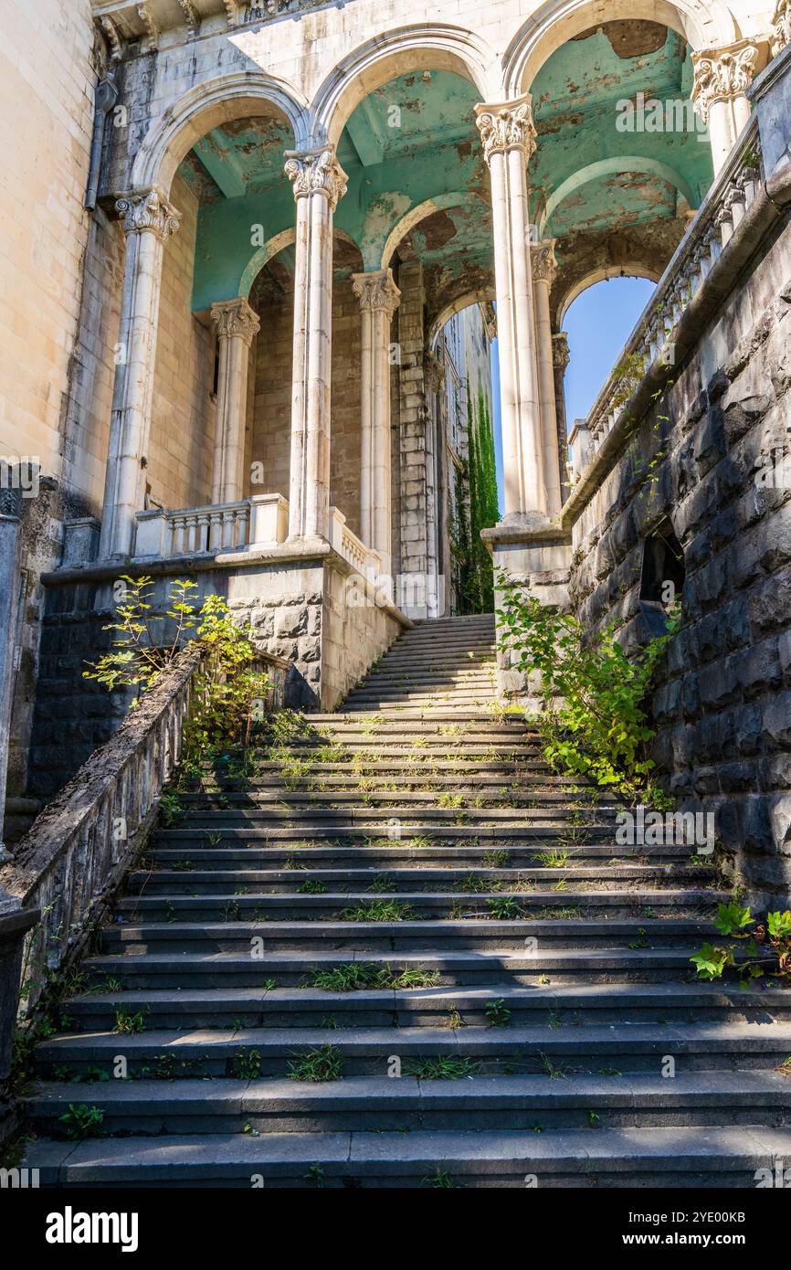 Abandoned building with ancient stone staircase leading to grand arches ...