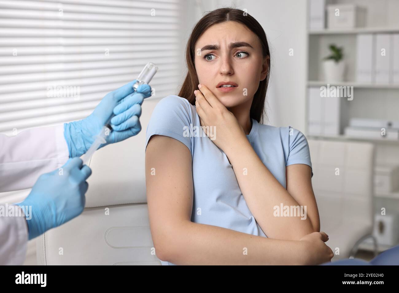 Dental phobia. Dentist with syringe and vial near scared woman in ...