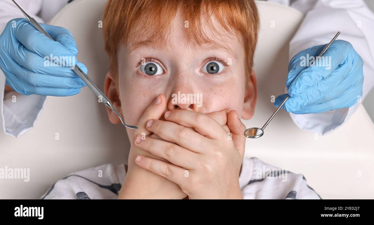Dental phobia. Dentist working with scared little boy Stock Photo - Alamy