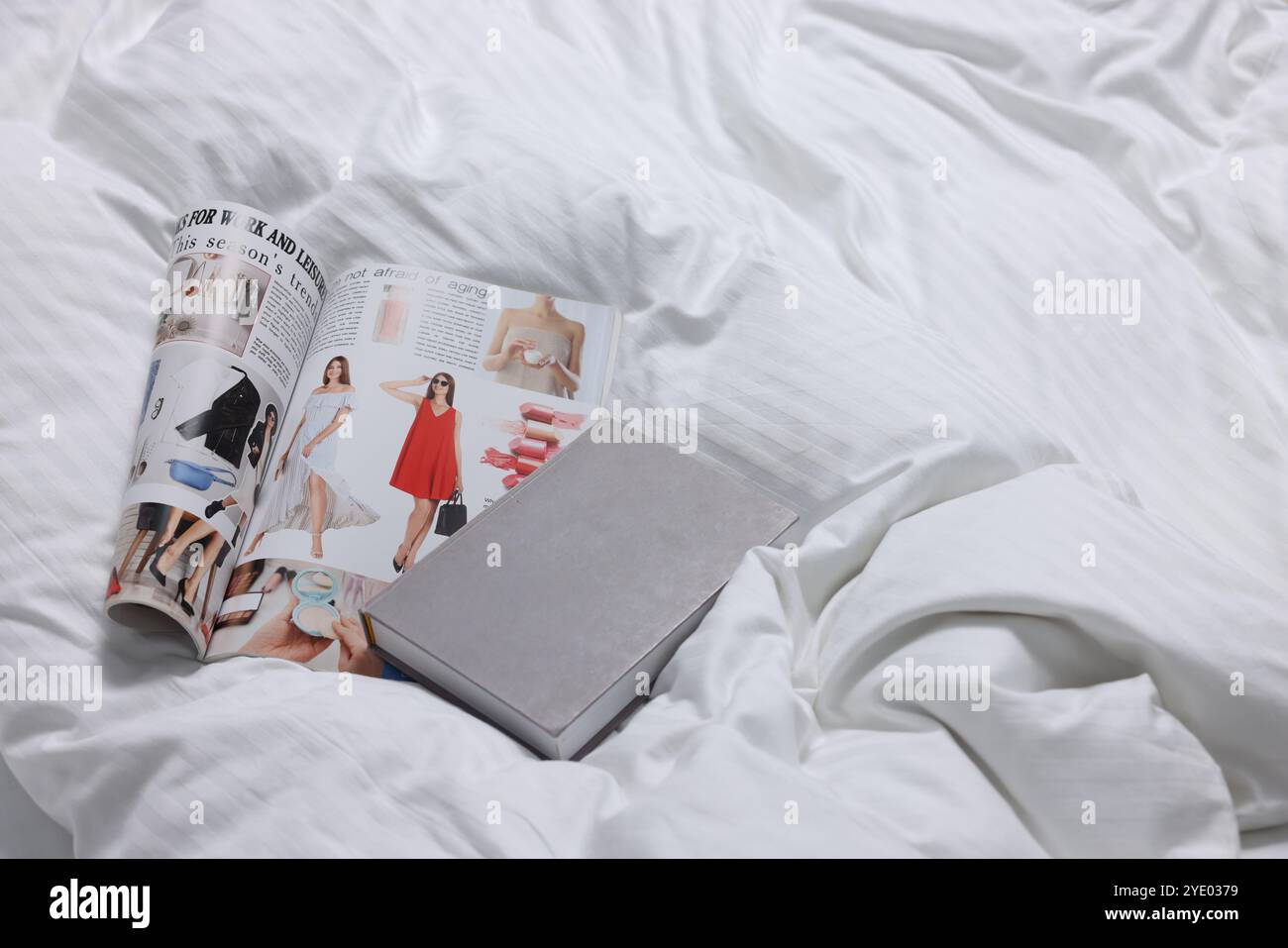 Magazine and book on bed with clean linens indoors Stock Photo - Alamy