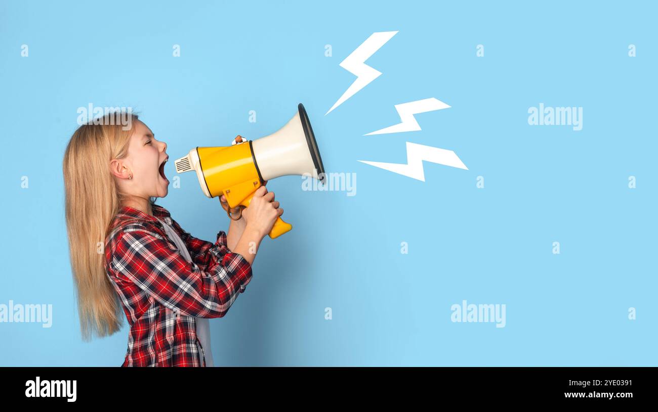 Emotional little girl shouting at copy space with megaphone, making ...