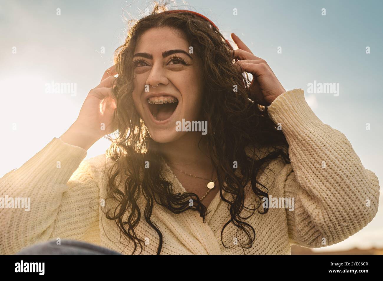 Authentic portrait of diverse young woman enjoying music with red ...