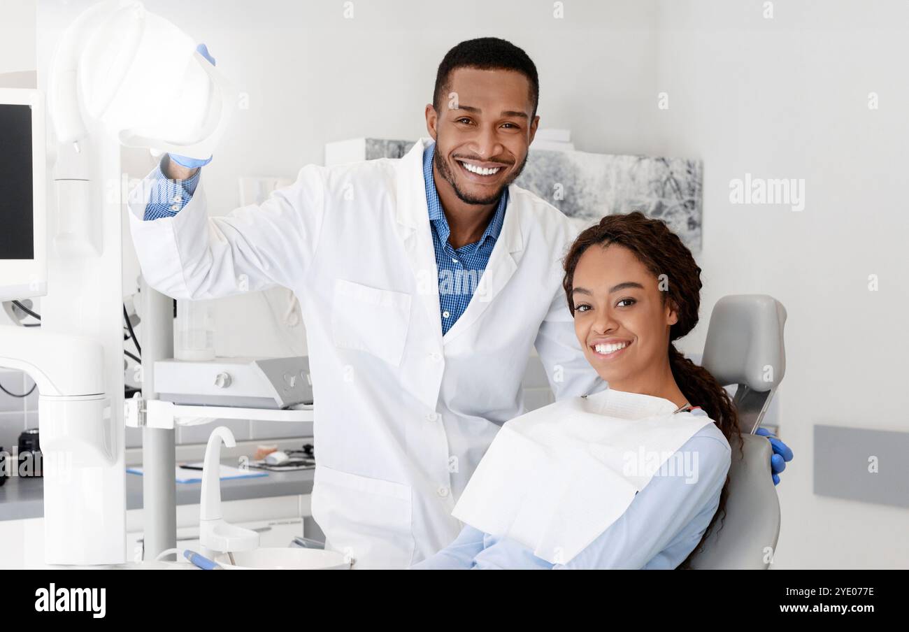 Dentist and patient posing together at modern dental clinic Stock Photo ...