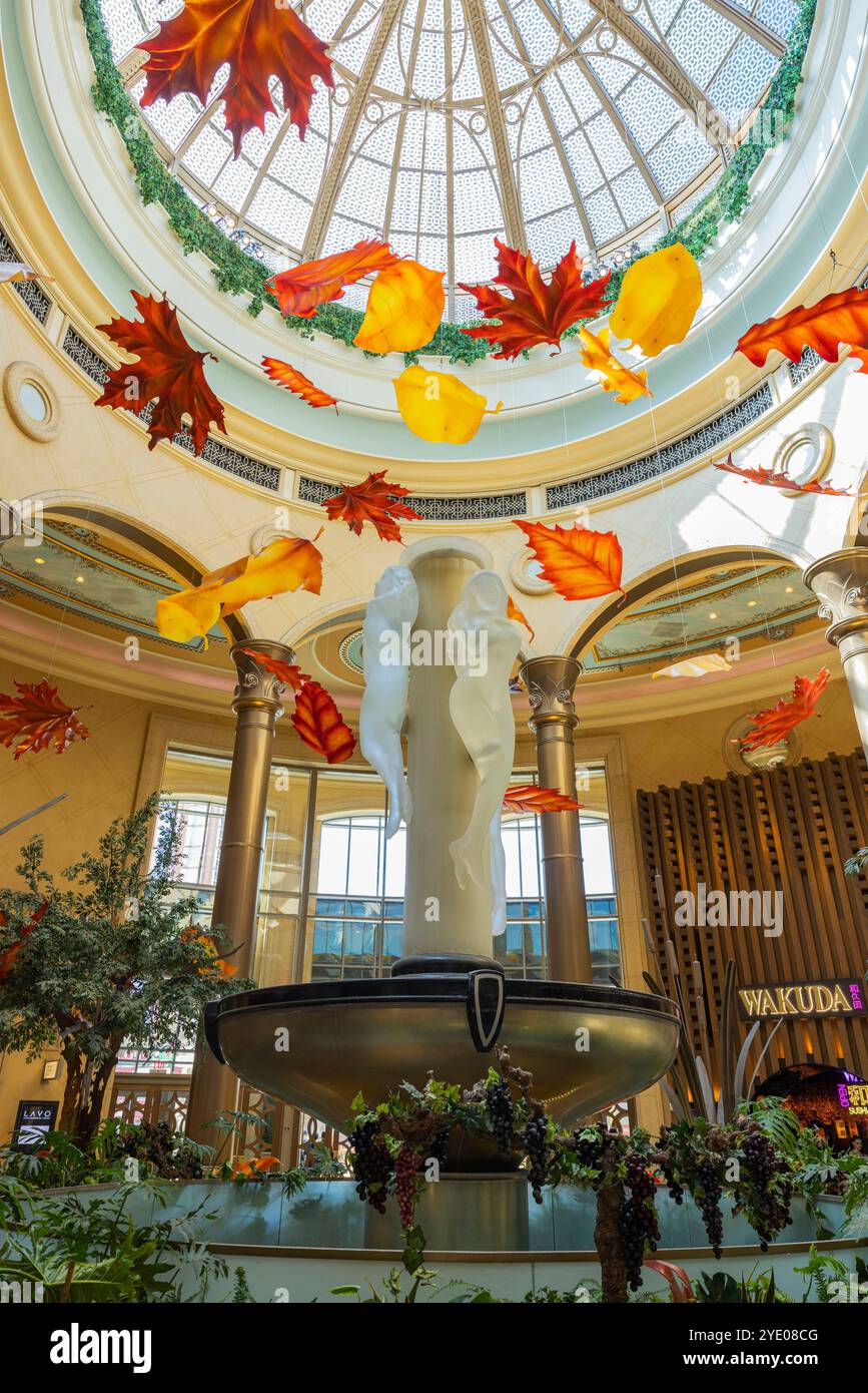Decorative fountain with sculptures and hanging autumn leaves in ...