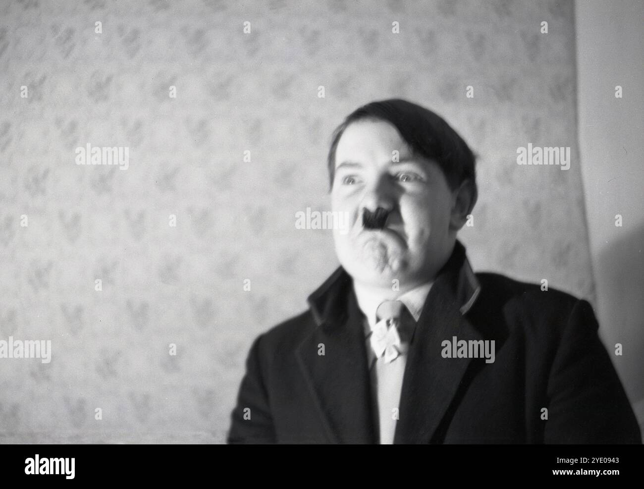 1950s, historical, older teenage boy doing an impersonation of German ...