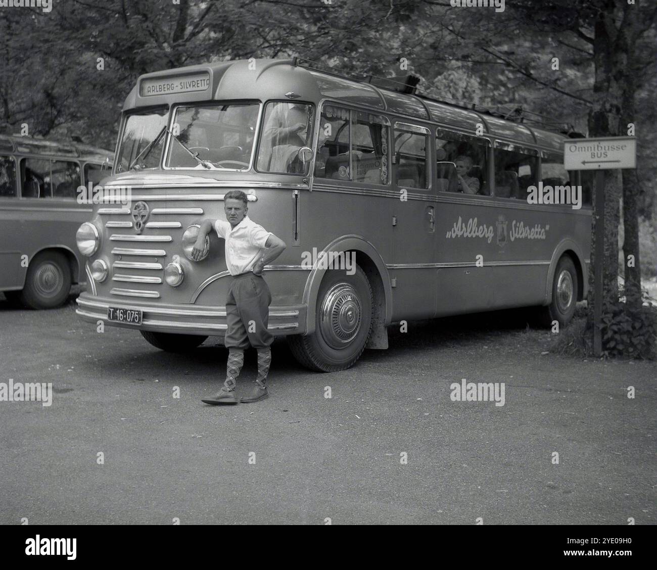 1950s, historical, Swiss coach driver in long socks standing beside his ...