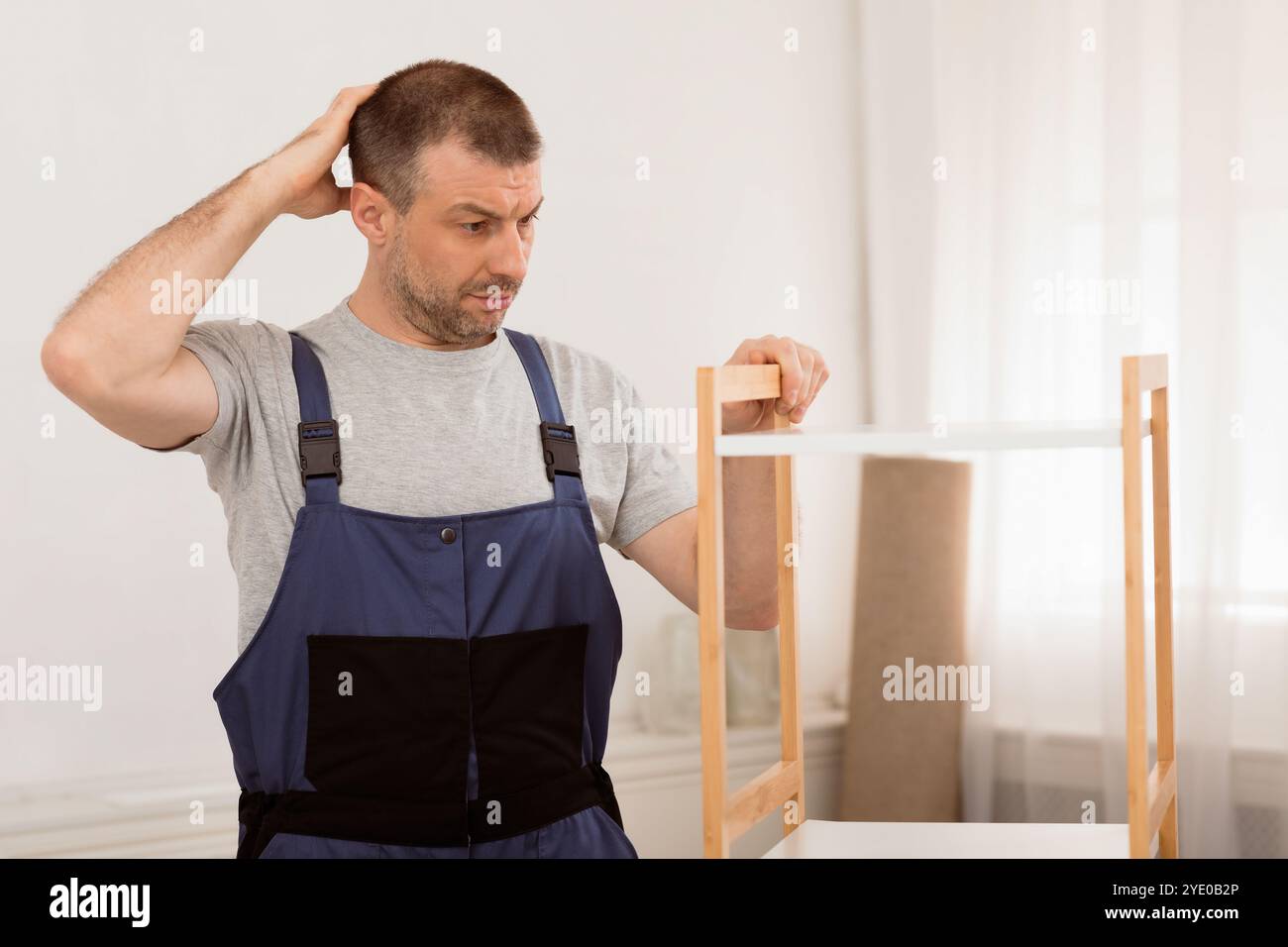 Confused male worker assembling shelf hi-res stock photography and ...