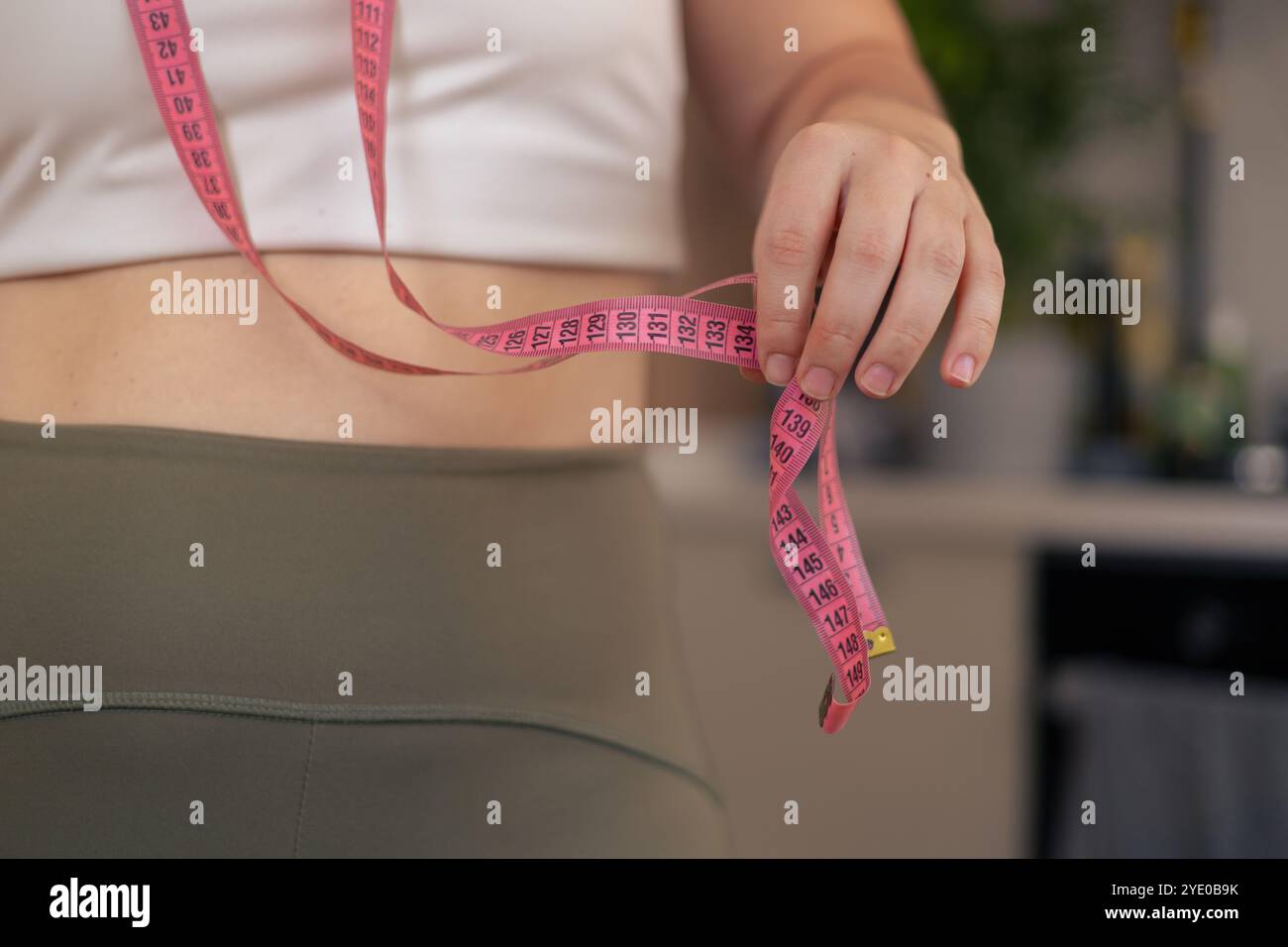 Measuring body size with a tape measure in a cozy indoor setting during ...