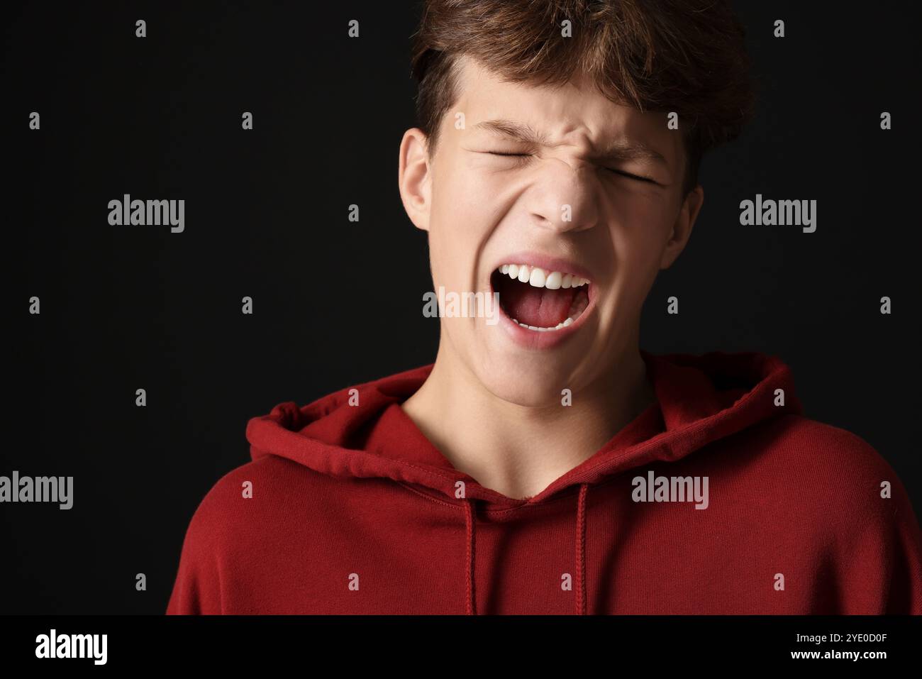 Scared teenage boy screaming on black background. Space for text Stock ...