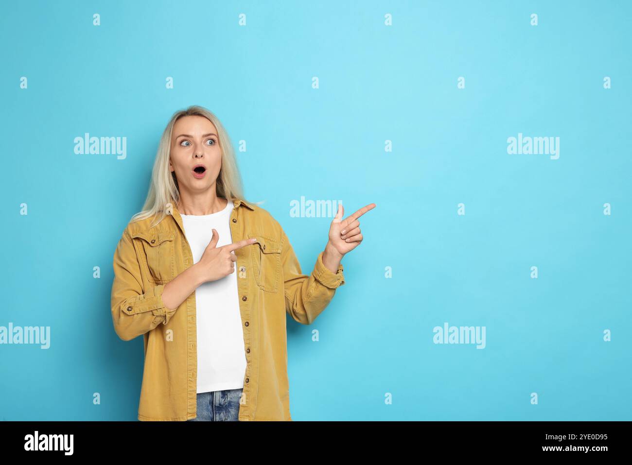 Portrait of scared woman on light blue background, space for text Stock ...