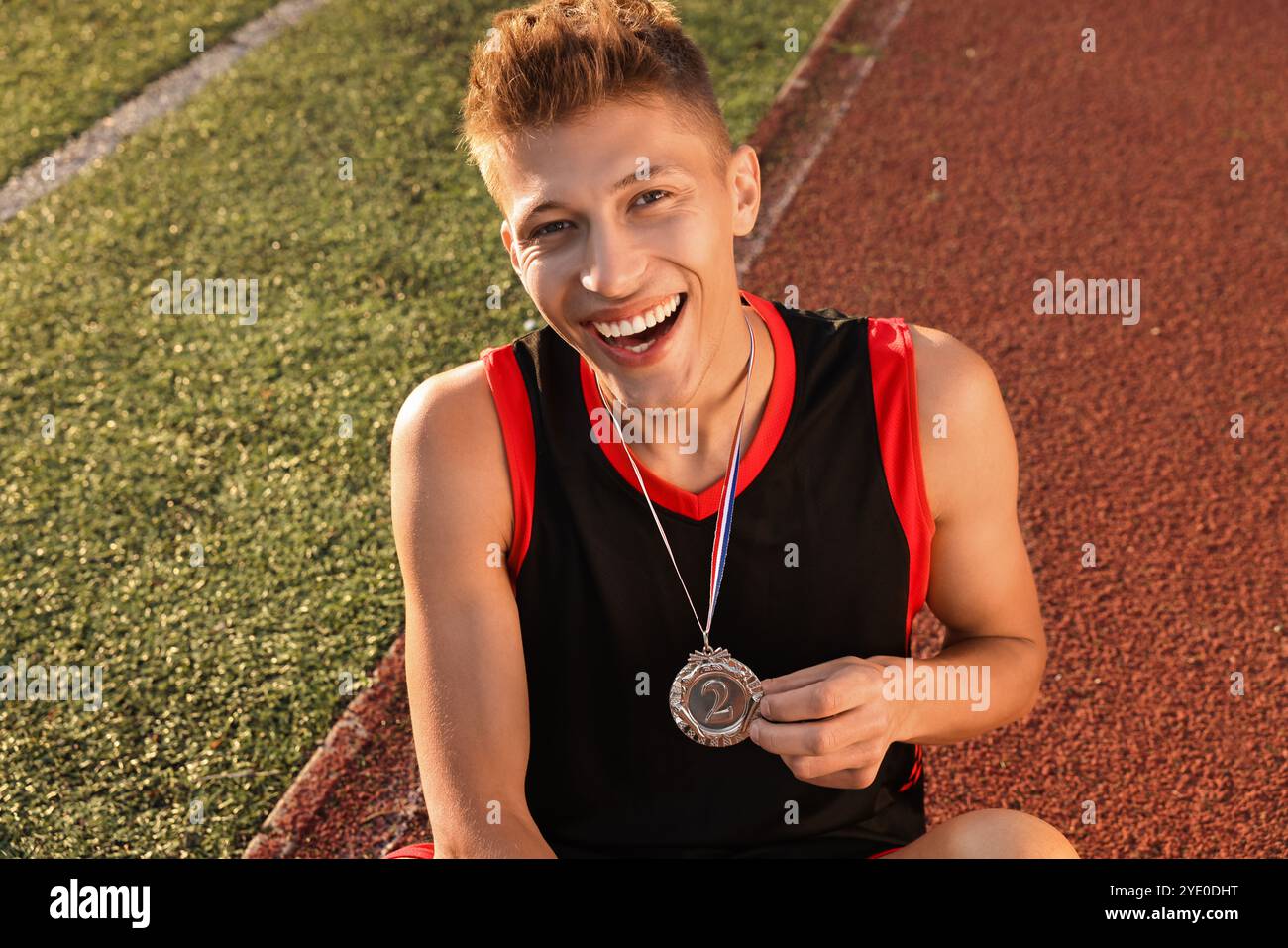 Happy winner with silver medal at stadium Stock Photo - Alamy
