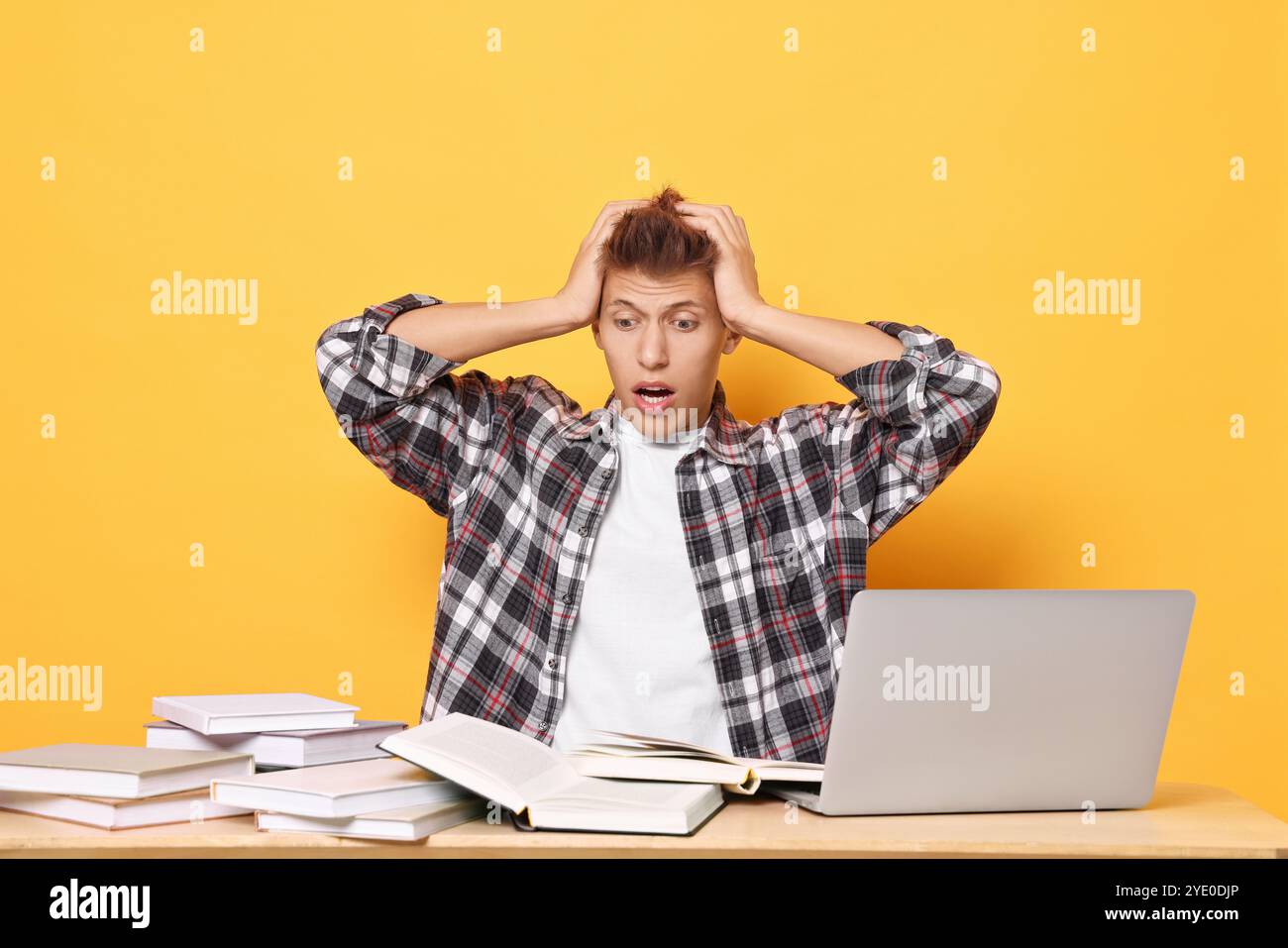Emotional student with books and laptop having stress before exam at ...
