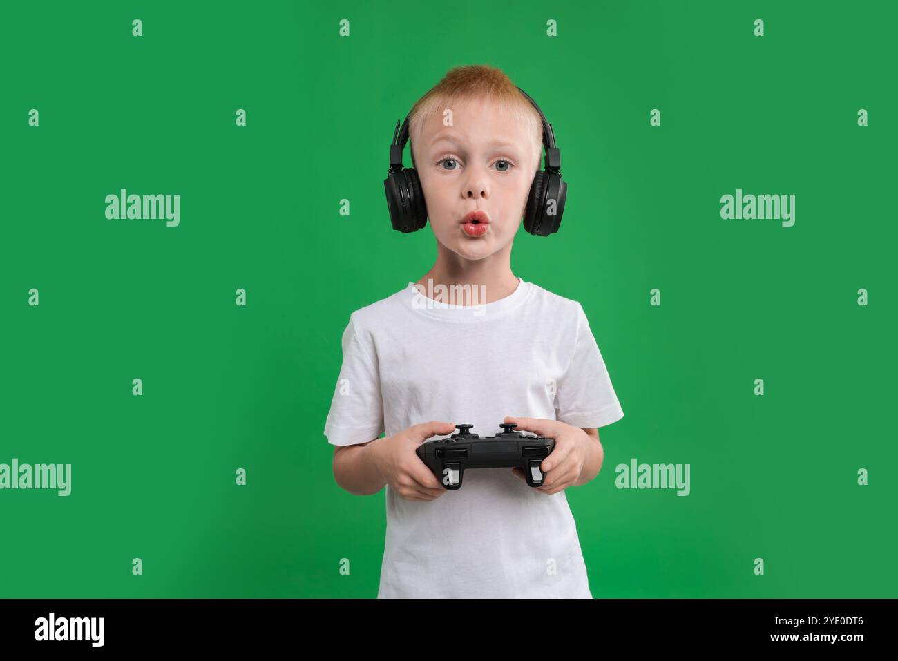 Cute little boy in headphones playing video game with controller on ...