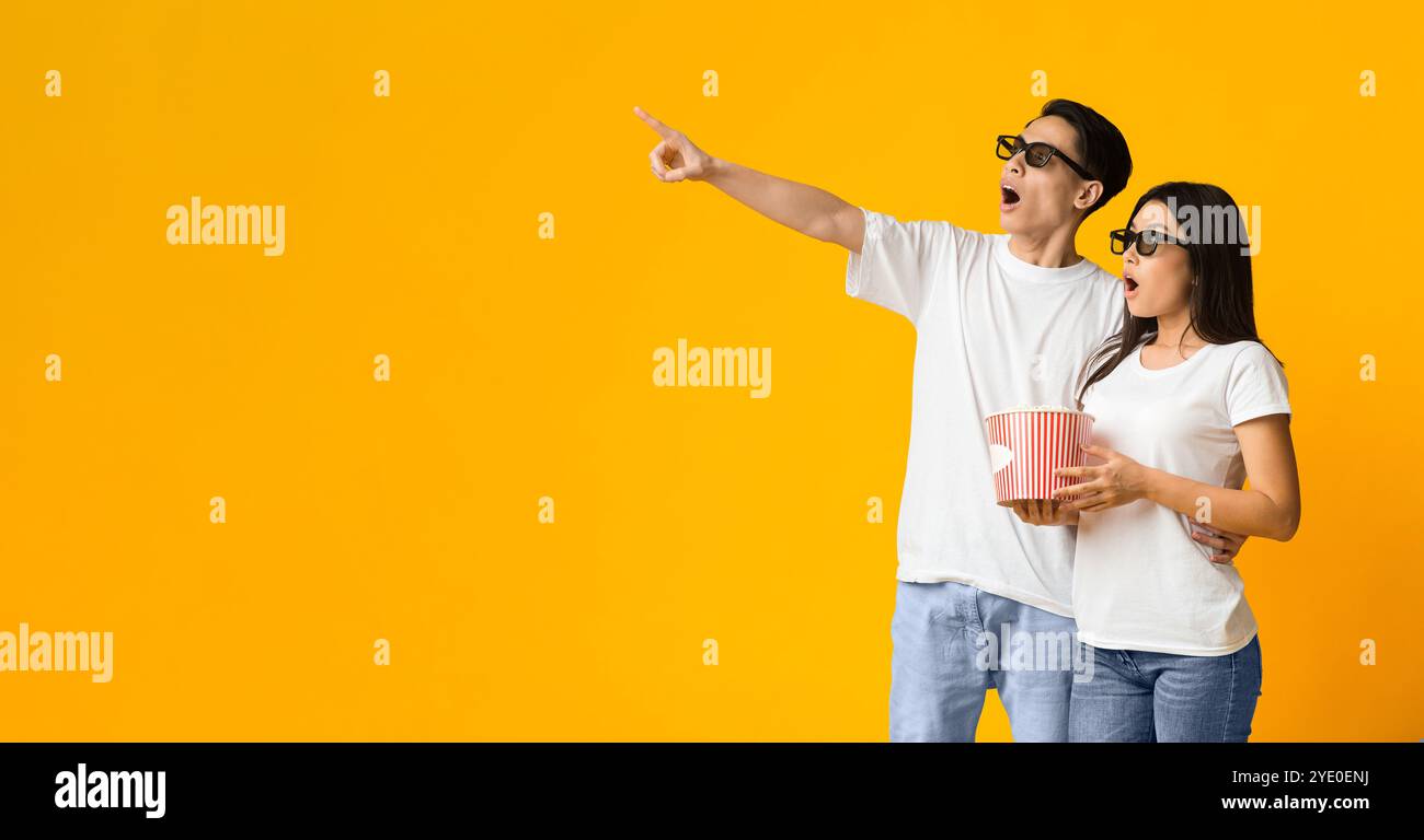 Shocked asian couple in 3d glasses watching movie with popcorn Stock Photo - Alamy