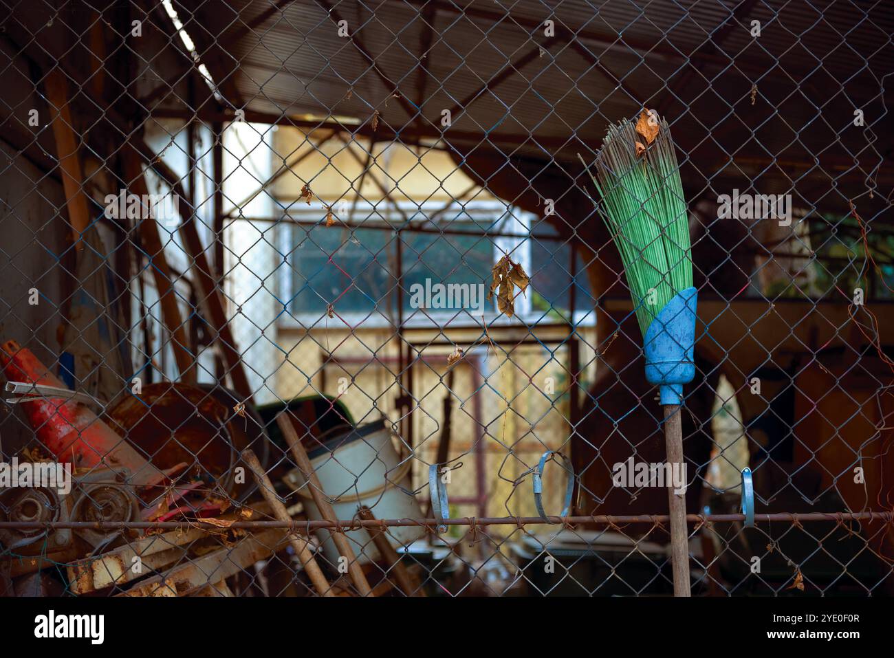 Janitor tools behind fence Stock Photo - Alamy