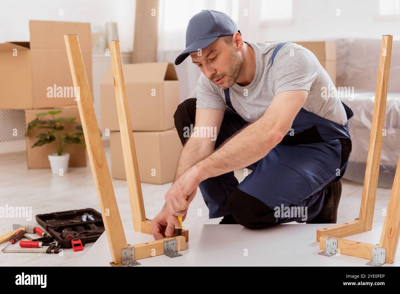 Carpenter Working Assembling Desk Installing Furniture After Relocation ...