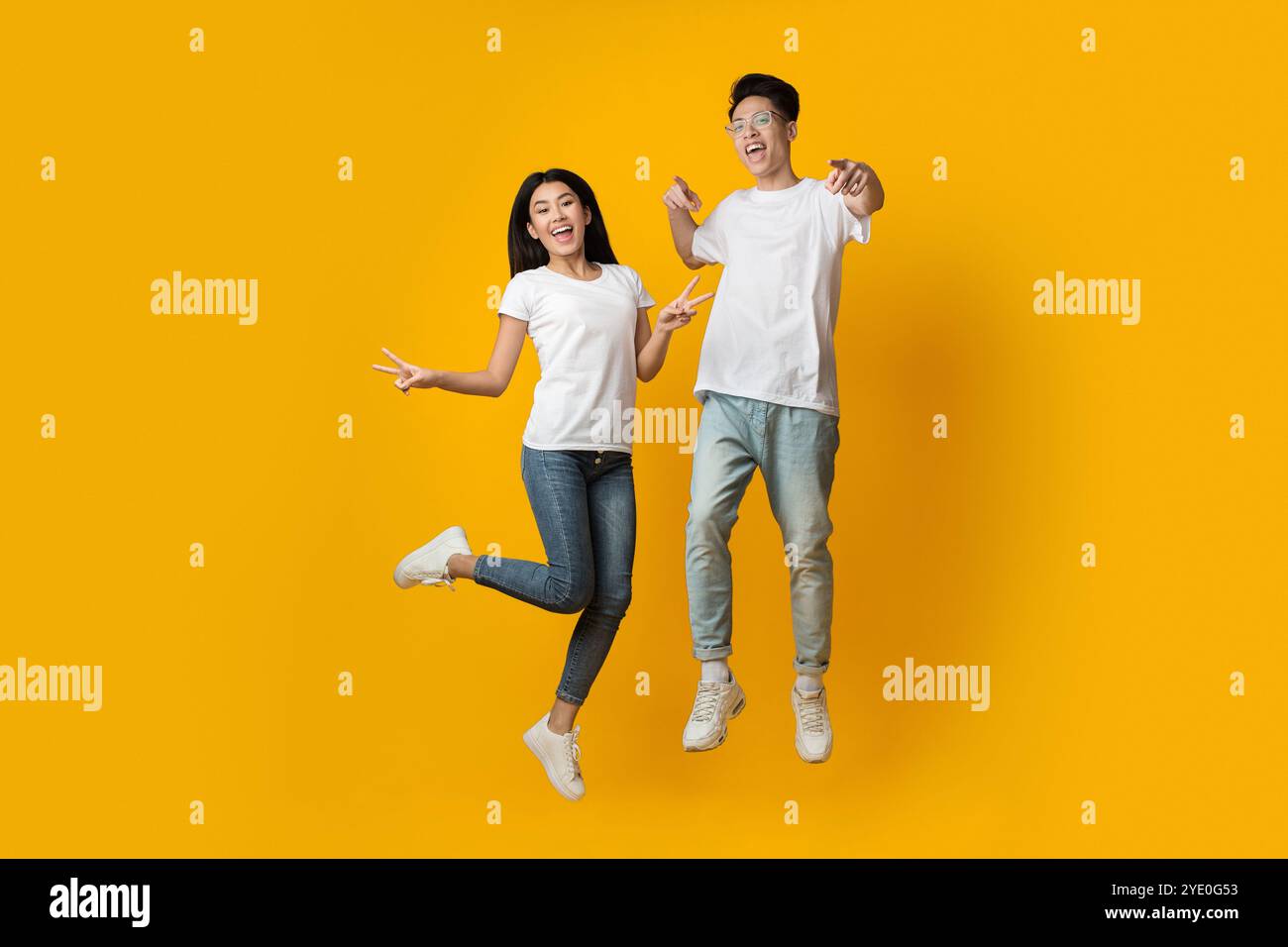 Carefree asian millennial couple happily jumping in air Stock Photo - Alamy