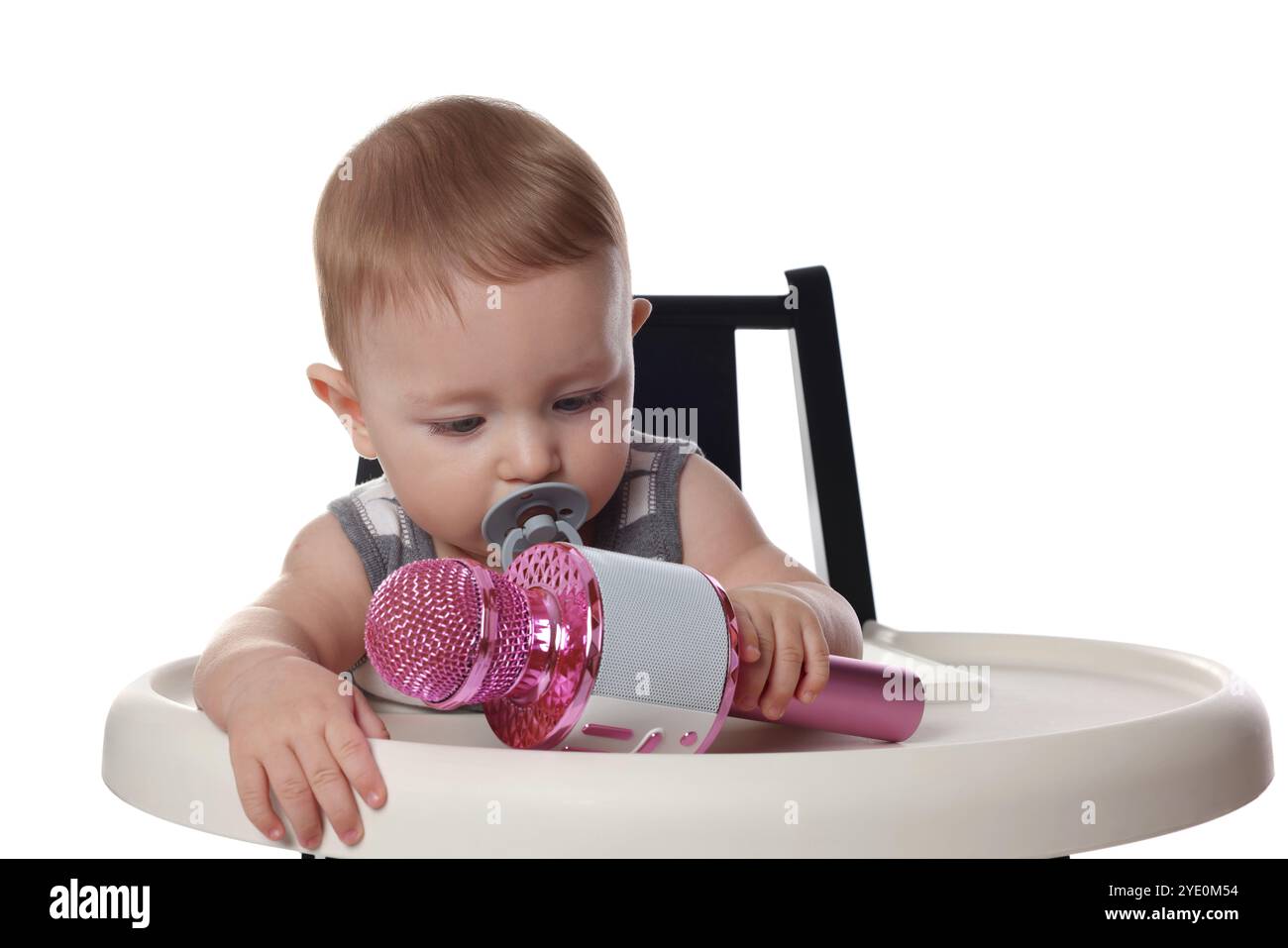 Cute little baby with pacifier and microphone in high chair on white ...