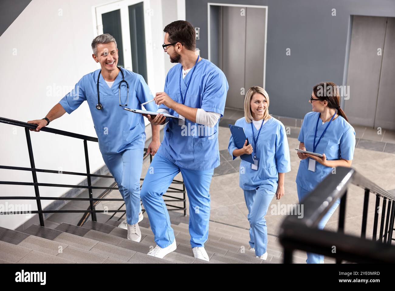 Healthcare workers walking up stairs in hospital Stock Photo - Alamy