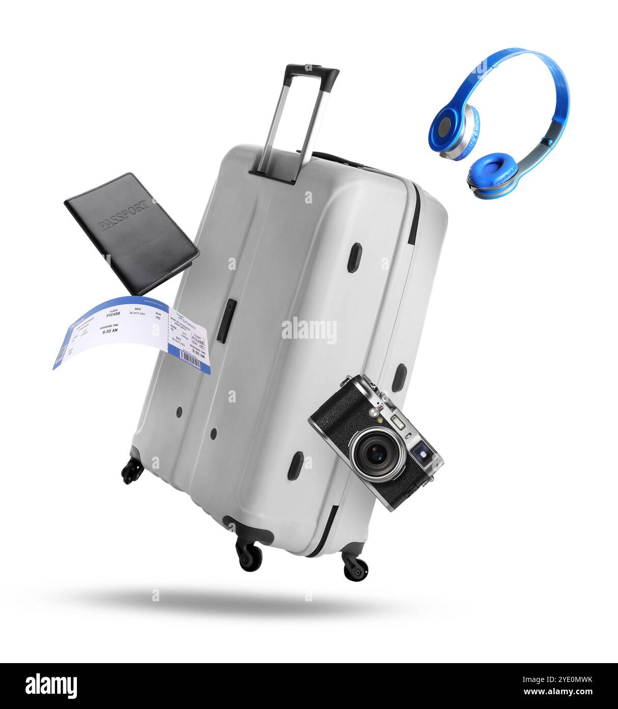 Suitcase, passport, ticket, headphones and camera in air on white ...