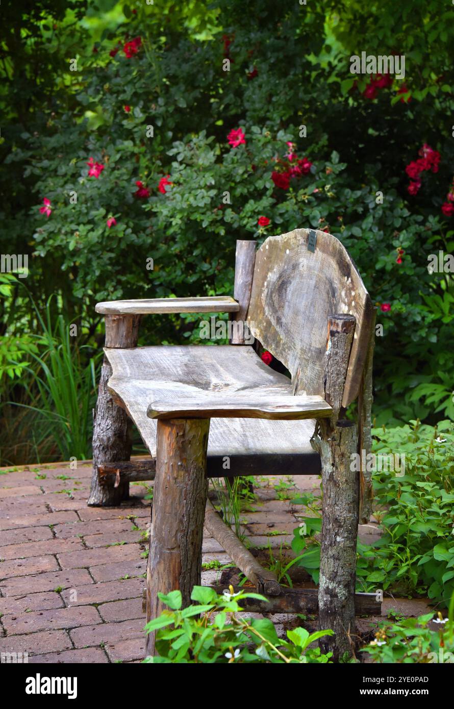 Rustic, wooden bench sits on a pad of brick. It occupies a quiet corner ...