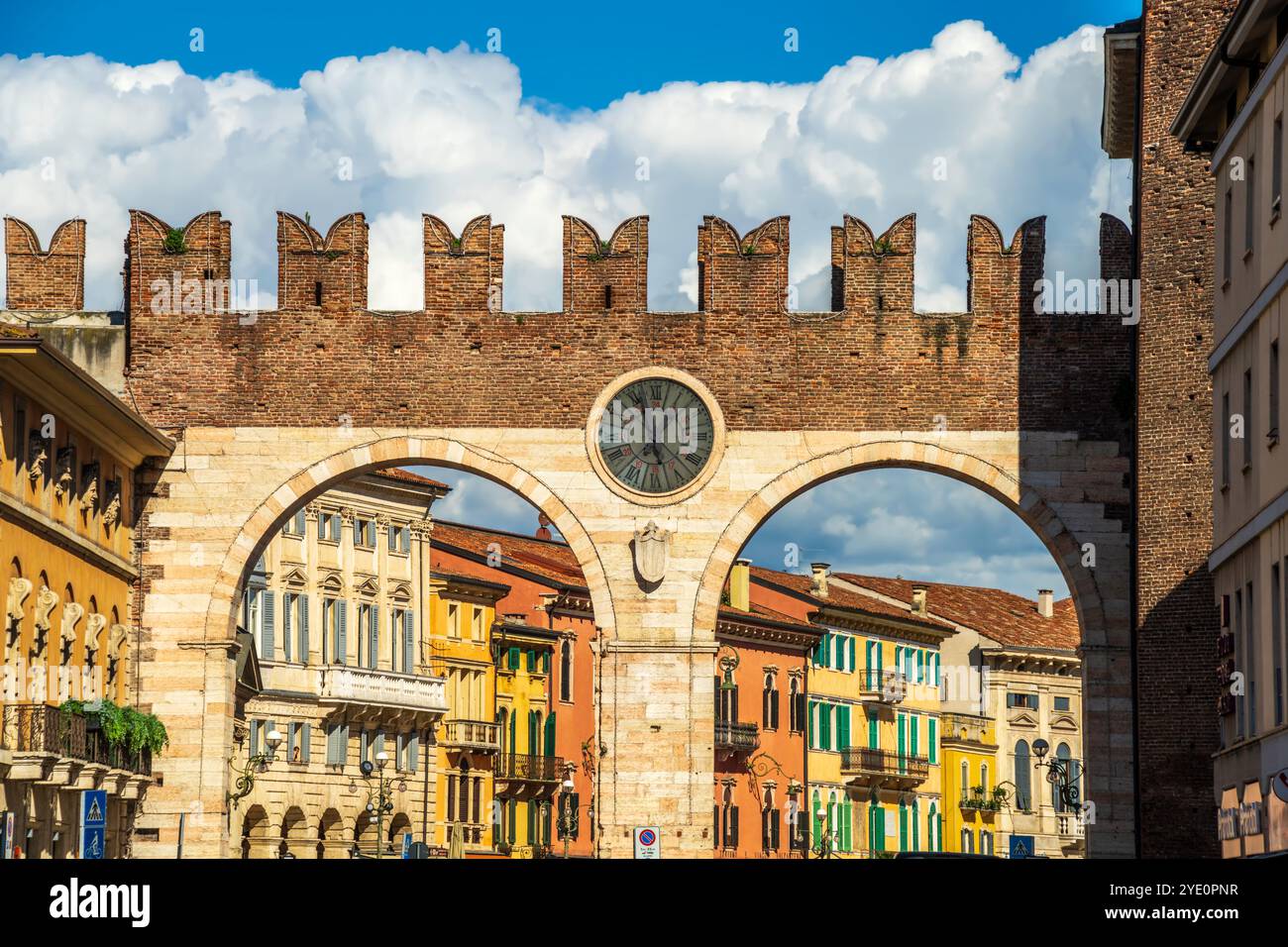 Verona cityscape of medieval city walls and clock on the ancient city gate, known as Portoni ...