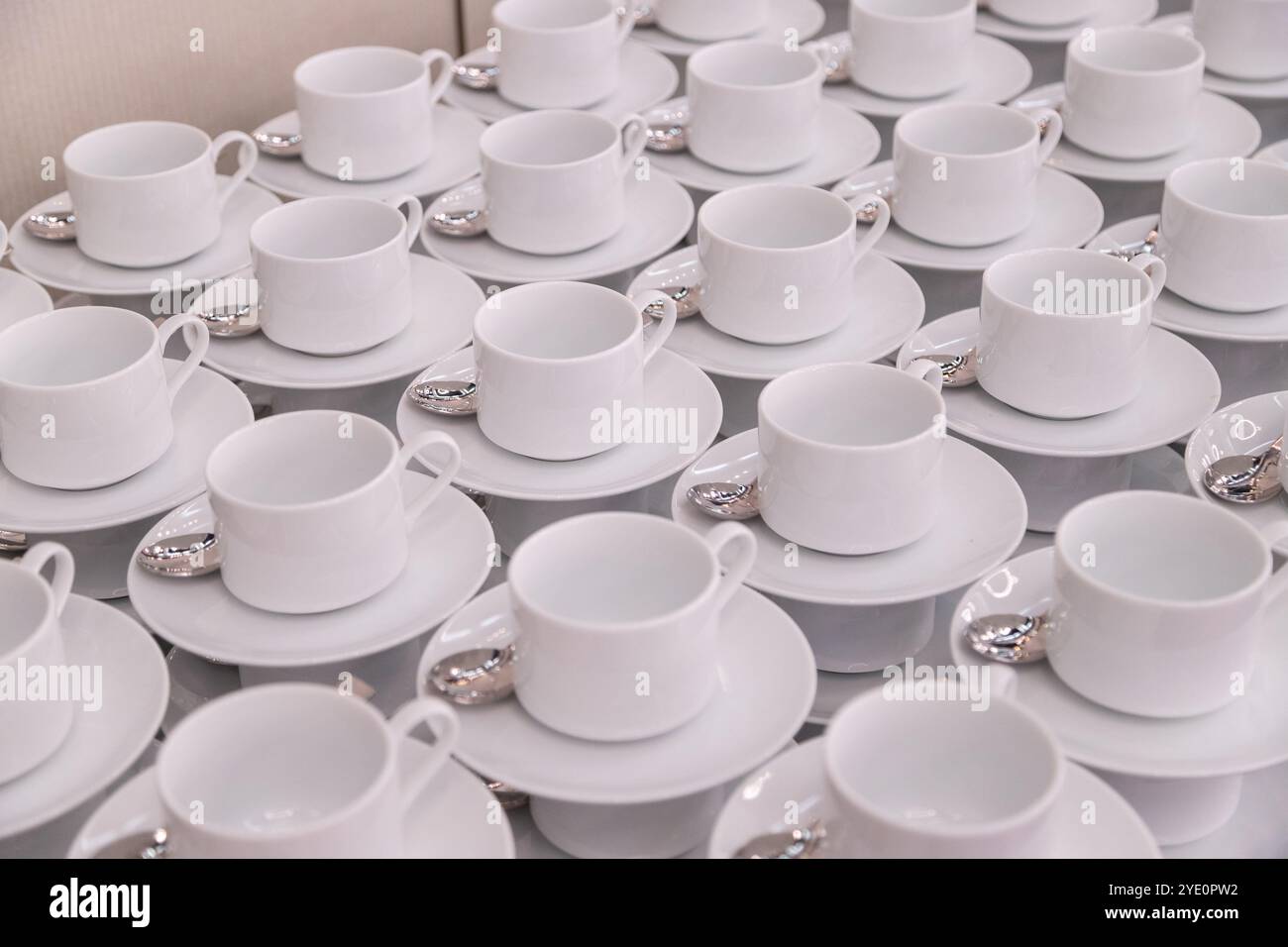 A large number of cups, saucers and teaspoons at an event ready for ...