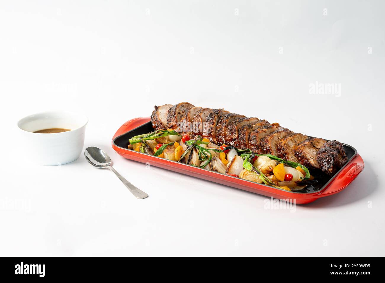 Woke roasted loin of pork with roasted fresh vegetables on a serving ...