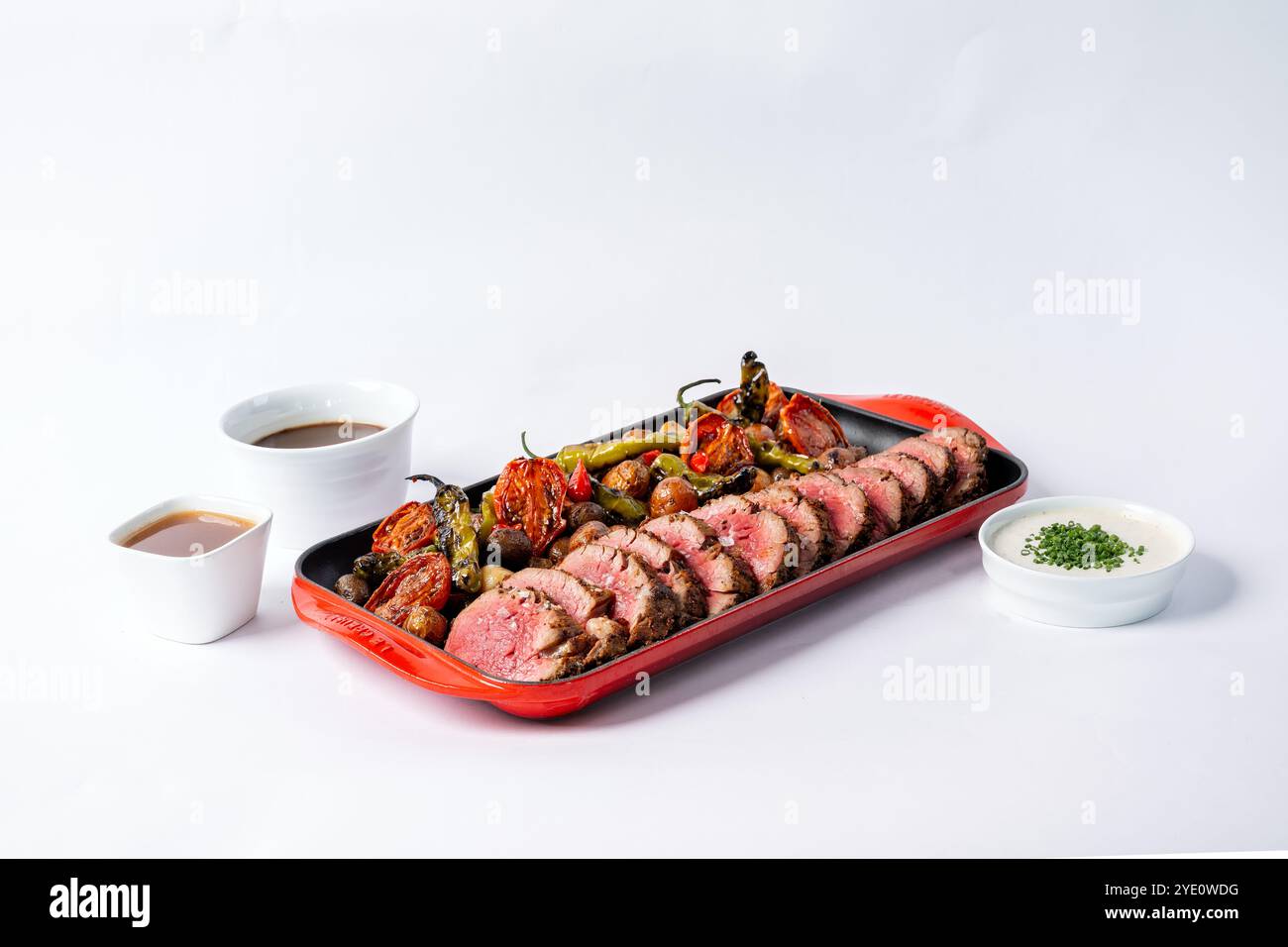 Beef Tenderloin on a platter with a trio of sauces and roasted peppers ...