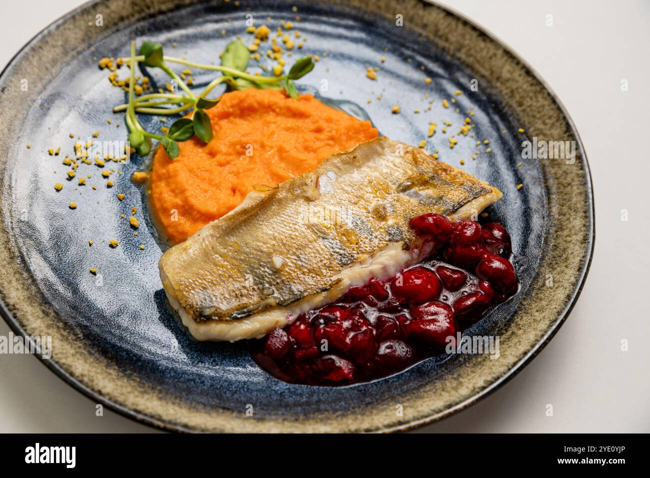 Baked fish fillet with mashed sweet potatoes and berry sauce, served ...