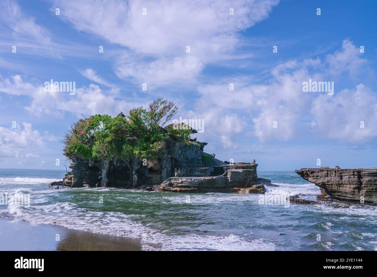 Waves crashing on rocky shore at tanah lot temple, a hindu pilgrimage ...