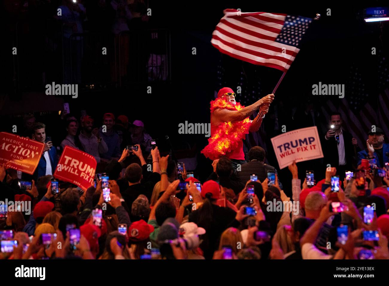 Wrestler Hulk Hogan waves an American flag as he crossed to the stage ...