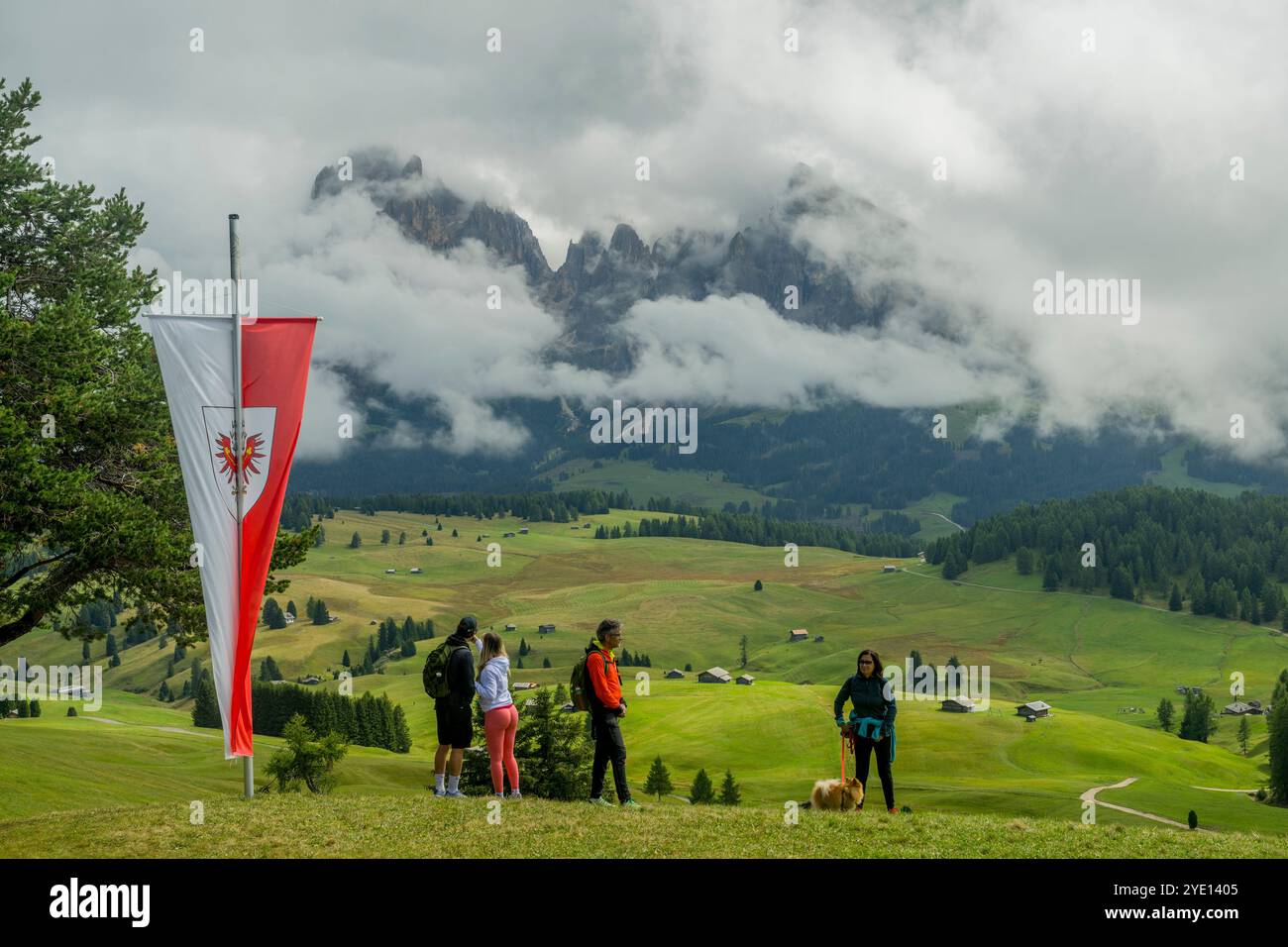 Hikers at a Tyrolian flag at an Almgasthof (restaurant) on the Seiser ...