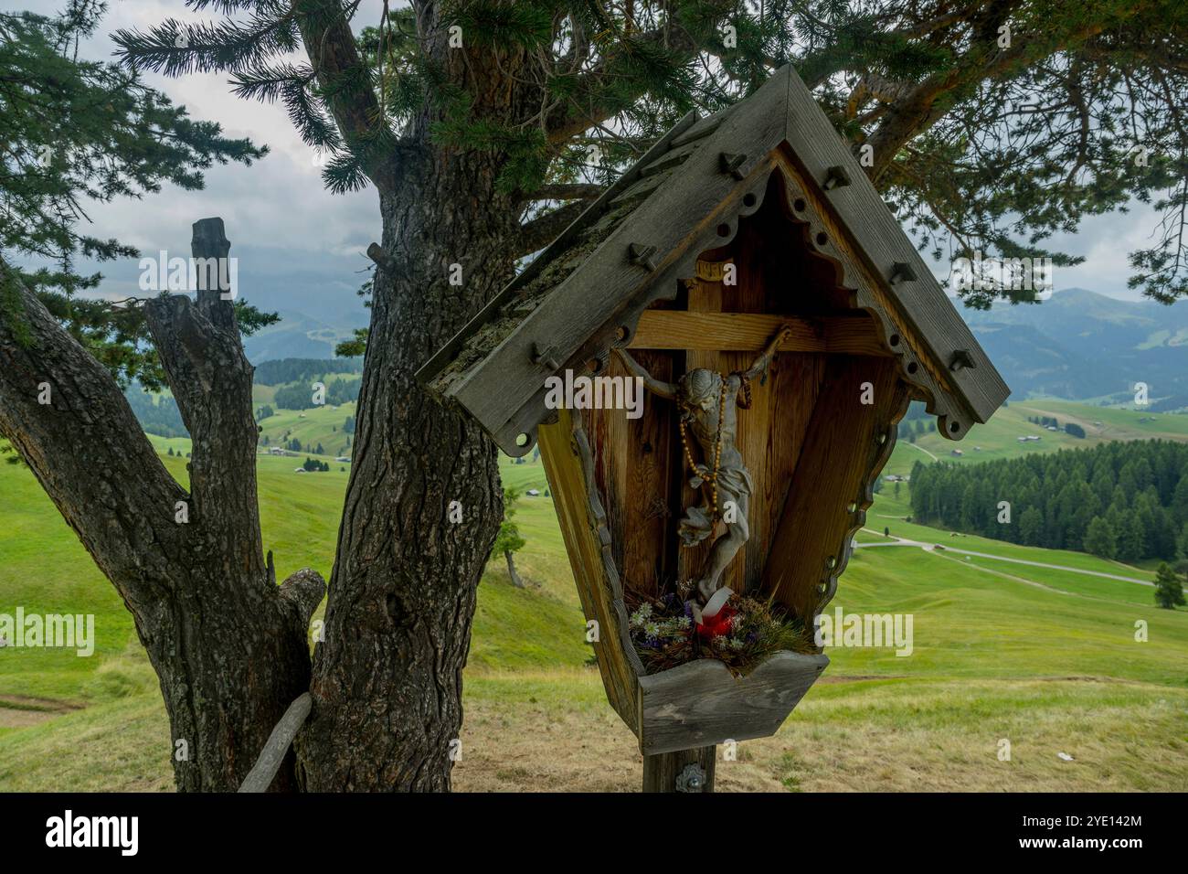 A typical wooden wayside cross on the Seiser Alm (Alpe di Siusi), the ...