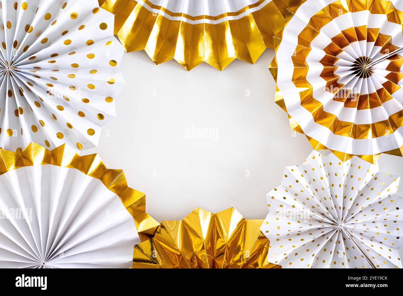 Tissue gold paper fans and honeycombs on the white background. Holiday ...