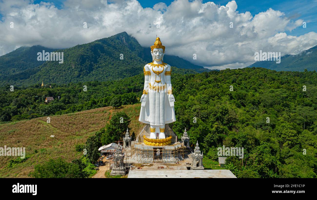 Big Buddha Brahma Panyo standing tall in front of Doi Luang mountain ...