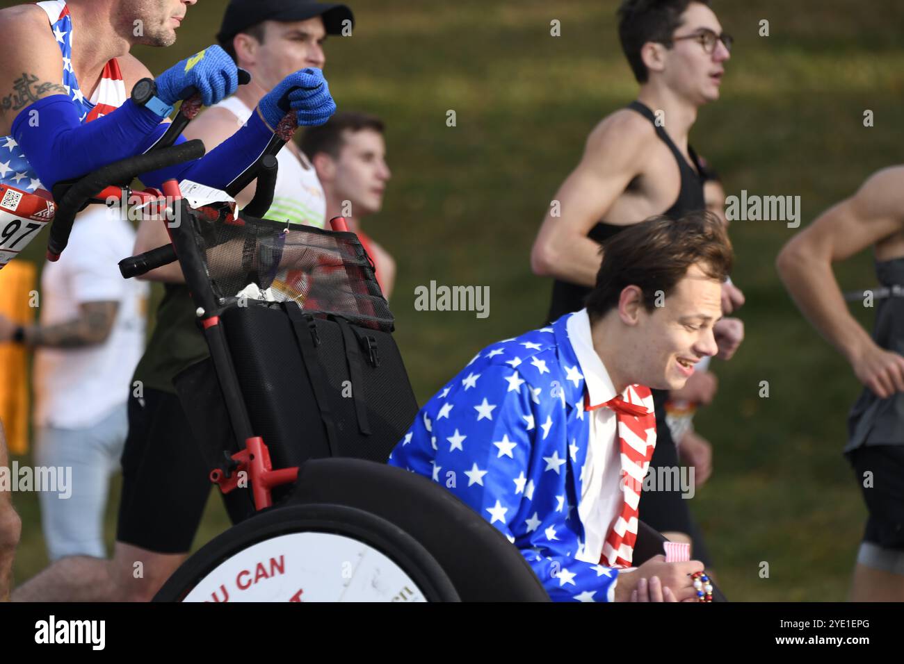 Male runner wearing red white and blue colors pushing disabled person ...