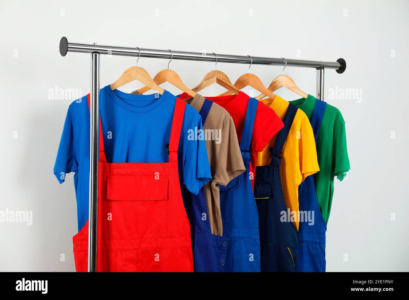 Workers' uniforms on clothing rack near grey wall indoors Stock Photo ...